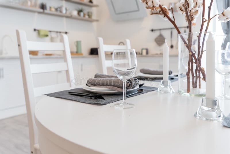 Dining Table with White Plate Setting in Modern Home. Cotton Branches ...