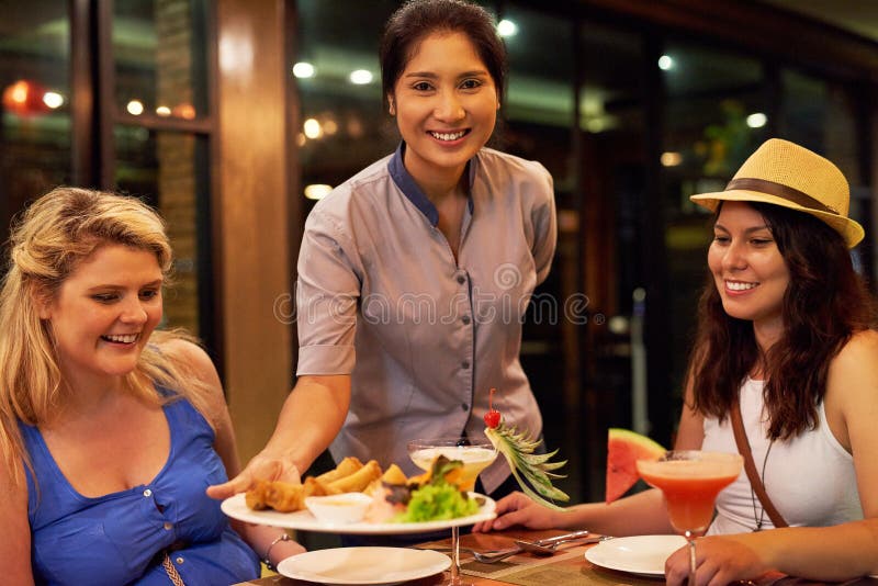 Dinner is Served. Portrait of a Waitress Serving Customers at a ...