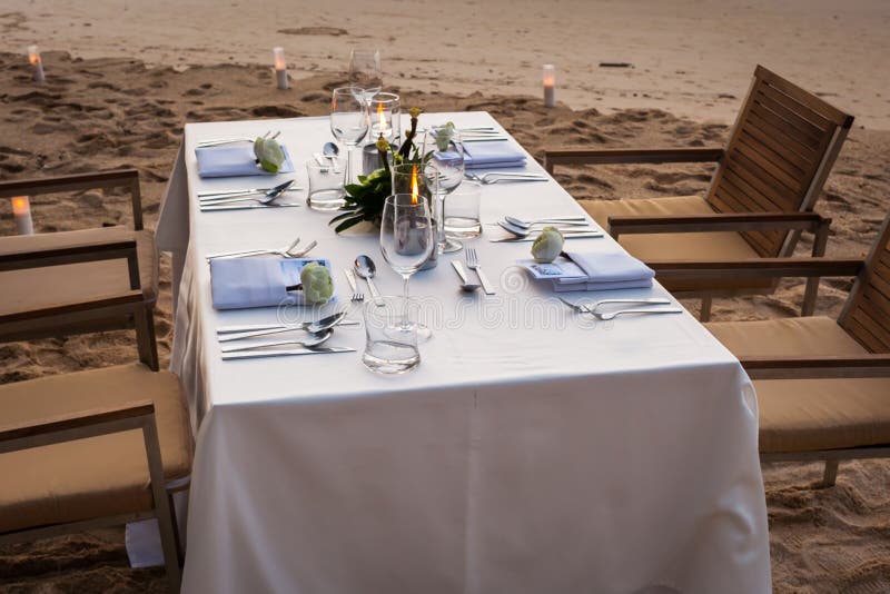 Dinner table on the beach. stock photo. Image of plate - 180366606
