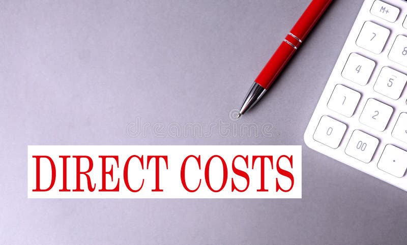 DIRECT COSTS Text Written on a Gray Background with Pen and Calculator ...