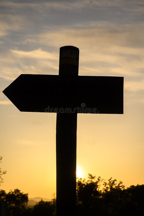 Direction Indicator Sign with Arrow Backlit Silhouette with Orange Sky ...