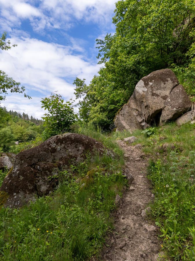 A Dirt Path in the Middle of a Grassy Field Next To a Large Rock Stock ...