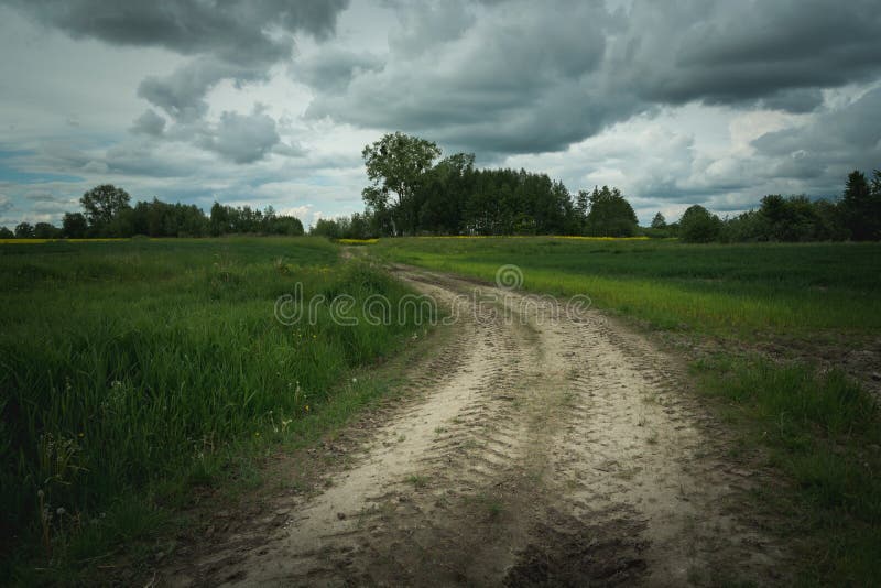 Dirt Road through Fields and Dark Clouds Stock Image - Image of scene ...