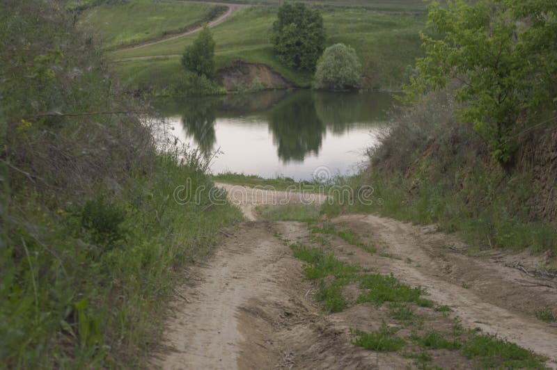 A Dirt Road Leading To a Pond Stock Photo - Image of leading, wall ...
