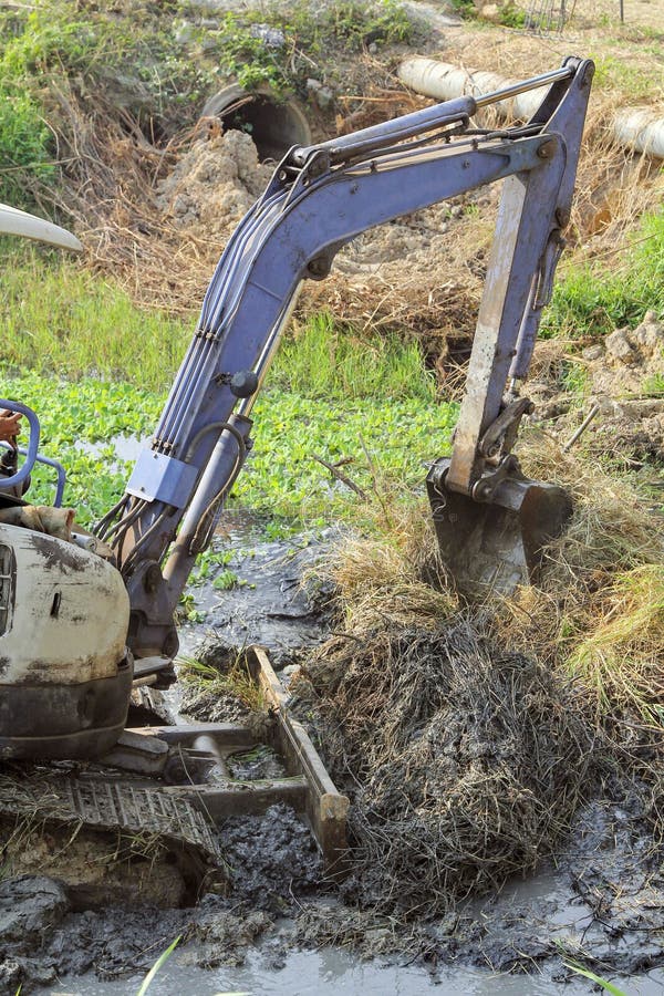 Dirty Bucket of Backhoe Digging Mud and Weed in a Canal. Stock Image ...