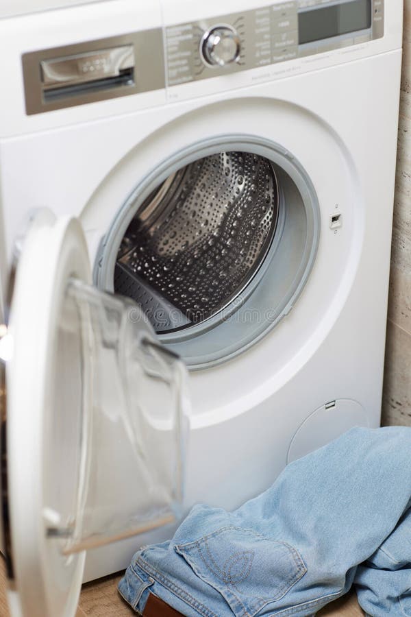 Dirty Jeans and Open Washing Machine in Laundry Room. Stock Photo ...