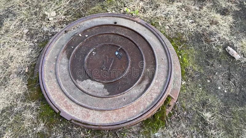A Dirty Rusty Iron Hatch with a Pattern is Located Next To Dry Grass ...