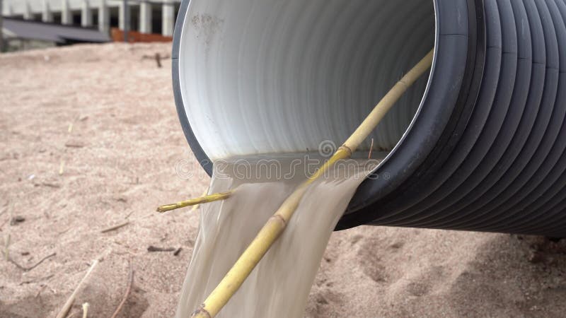 Dirty Water Pours from Sewer Pipe, Dried Reed Stem Sticks Out from ...