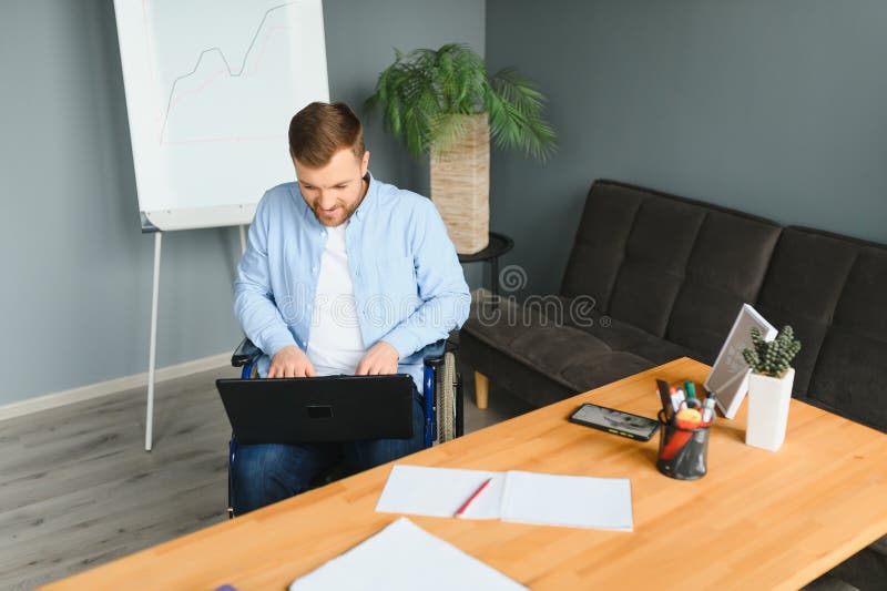 Disabled Businessman Sitting in Wheelchair Using Computer at Workplace ...