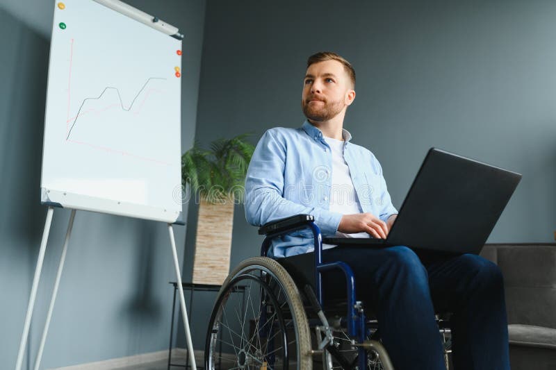 Disabled Businessman Sitting in Wheelchair Using Computer at Workplace ...