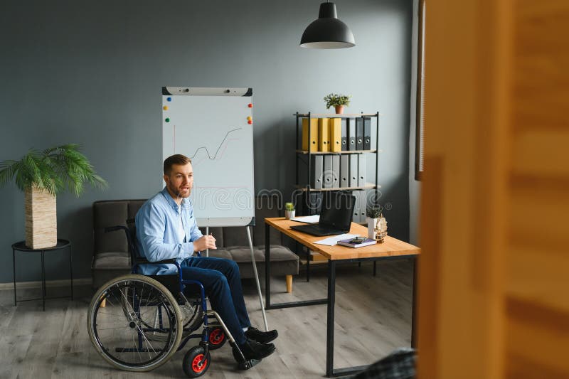 Disabled Businessman Sitting in Wheelchair Using Computer at Workplace ...