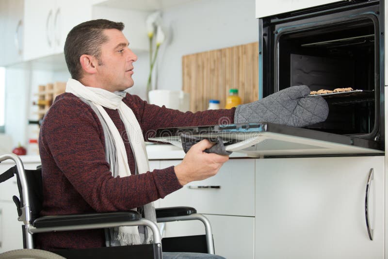 Disabled Man Taking Food from Oven Stock Photo - Image of baking ...