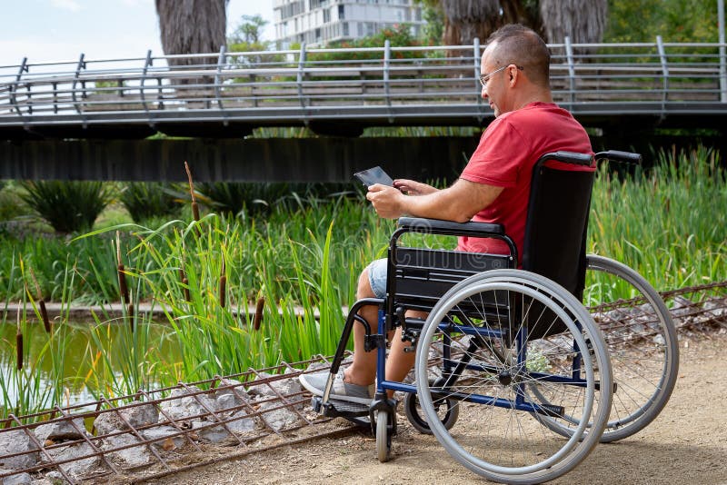 Disabled Man in Wheelchair Having Fun while Resting Using a Tablet ...