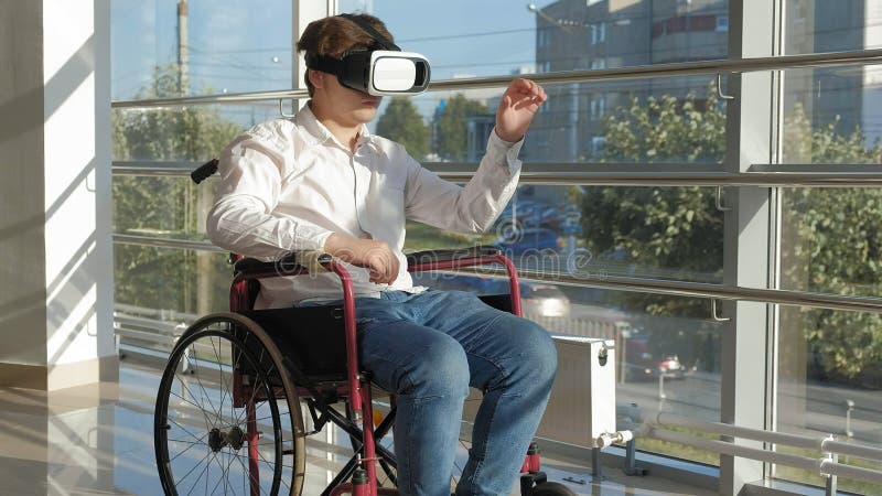 Disabled Man on a Wheelchair at a Window Uses a Helmet of Virtual ...