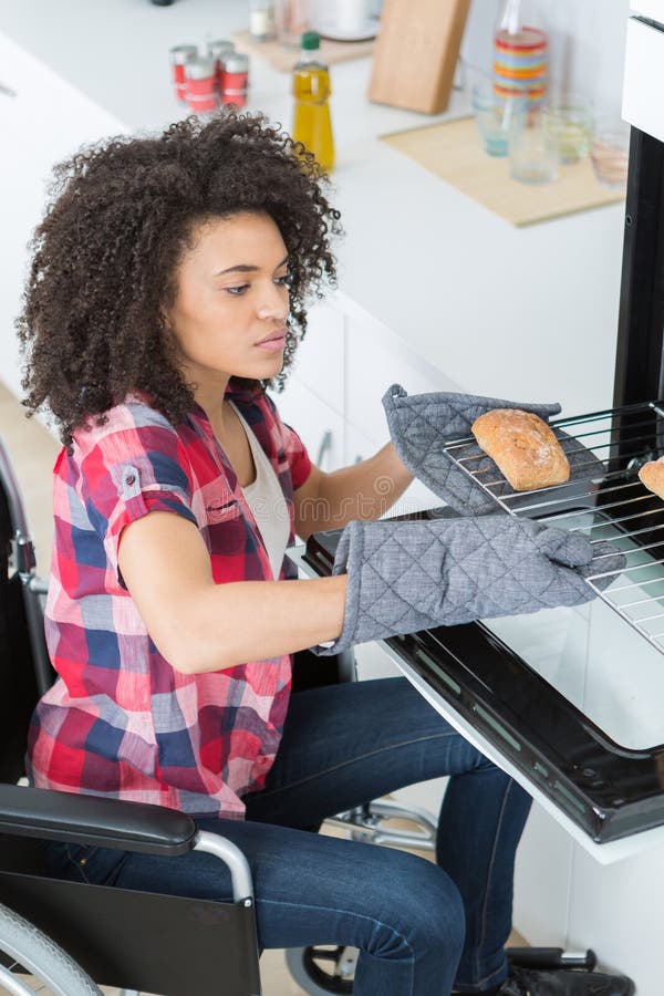Disabled Woman in Wheelchair Putting Bread in Oven Stock Image - Image ...