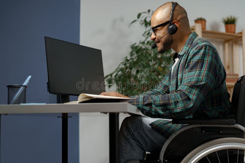 Disabled Young Man in Wheelchair Working at His Working Table with ...