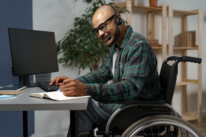 Disabled Young Man in Wheelchair Working at His Working Table with ...