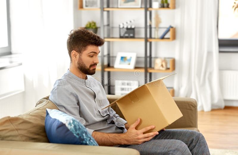 Disappointed Man Opening Parcel Box at Home Stock Photo - Image of home ...