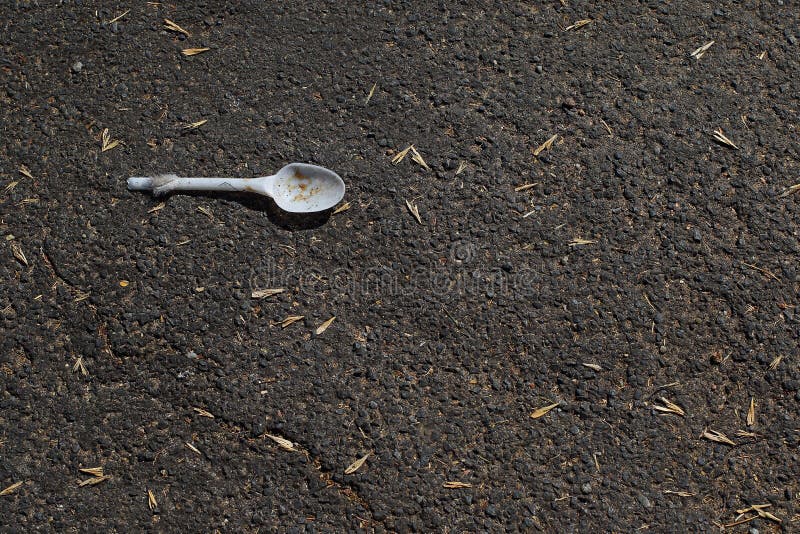 Discarded Plastic Spoon and Trampled Seeds on Tar Surface Stock Photo ...