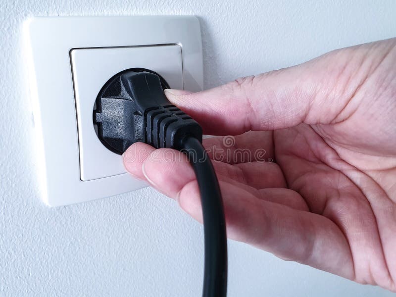 Disconnecting Black Electrical Power Plug with a Hand Inside a White ...