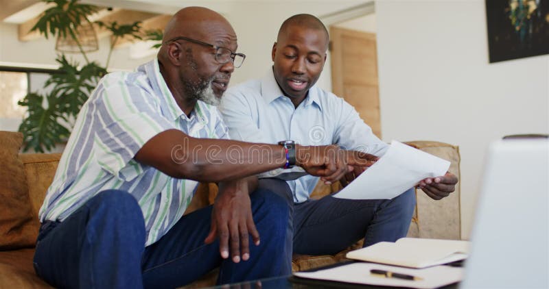 Discussing Documents, Financial Advisor and Client Sitting on Couch ...