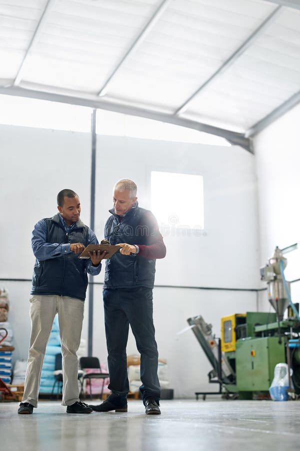 Discussing the Latest Numbers. Two Factory Managers Doing a Warehouse ...