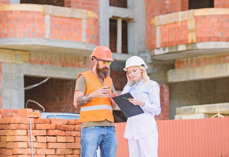 Discussing Plan. Woman Engineer and Builder Communicate at Construction ...