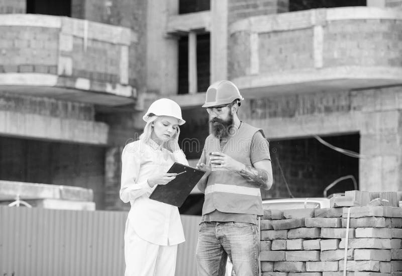 Discussing Plan. Woman Engineer and Builder Communicate at Construction ...