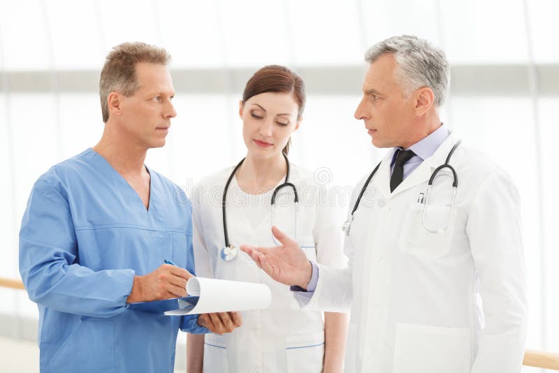 Discussing the Report. Hospital Doctors Discussing the Patient S Stock ... Discussing the Report. Hospital Doctors Discussing the Patient S Stock ...
