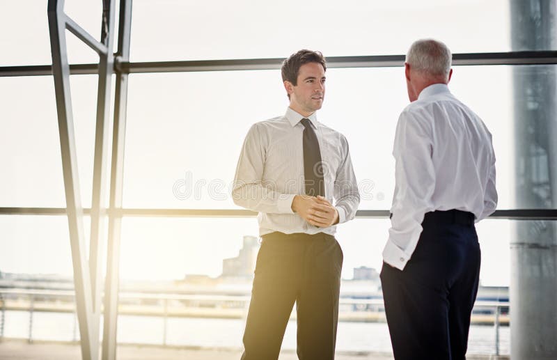 Discussing Some Ideas. Two Businessmen Talking in the Lobby. Stock ...