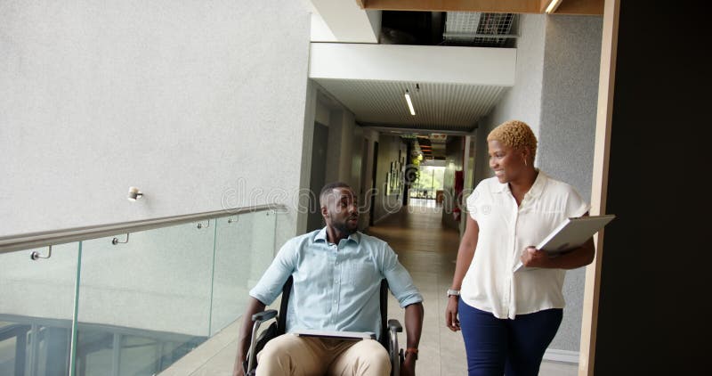 Discussing Work, Colleagues One Using Wheelchair with Tablet and ...