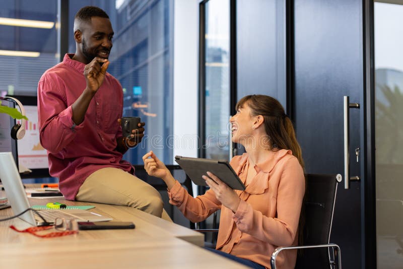 Discussing Work, Colleagues Using Tablet and Coffee Cup in Modern ...