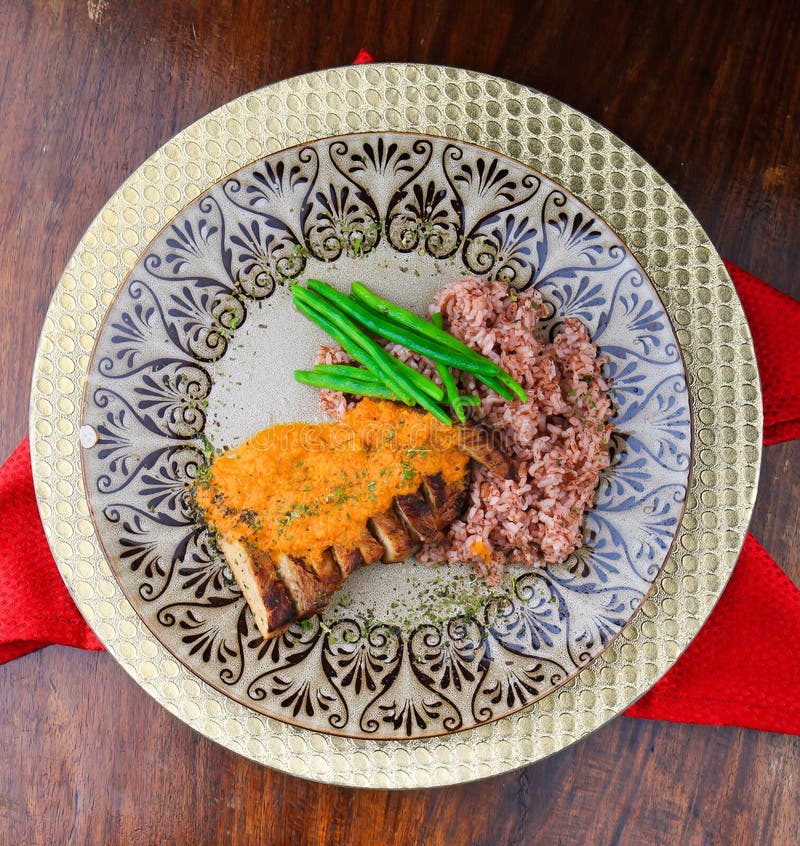 Dish of Sliced Meat, Rice and Greens with Orange Garnish Served on a ...