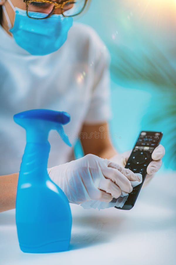 Disinfecting Remote Controller. Woman Disinfecting Remote Controller ...