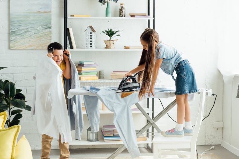 Children Ironing Clothes while Parents Drinking Coffee and Talking ...
