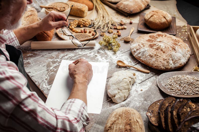 Old Baker Writing Down Old-time Recipe in Bakery Notebook Surrounded by ...