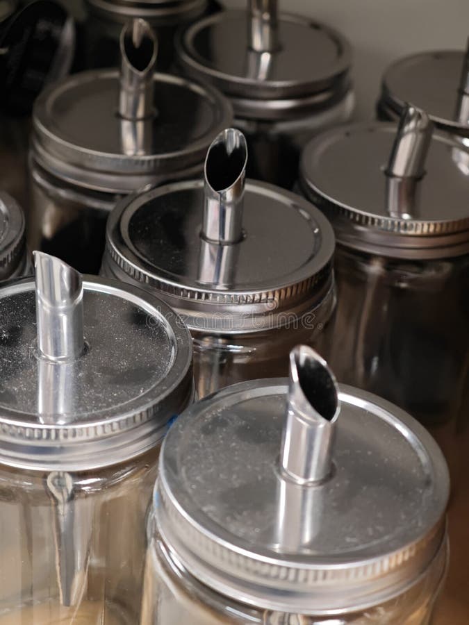 Display of Clear Glass Containers with Metal Spouts on a Shelf in a ...
