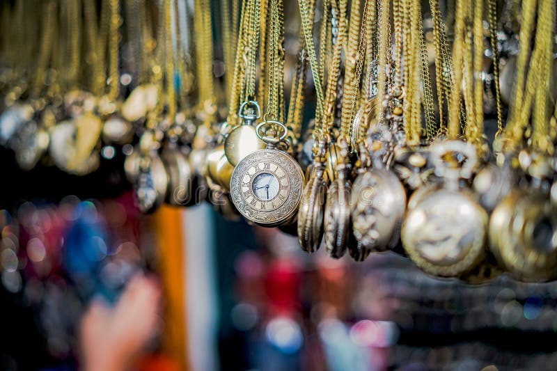 A Display of Gold and Silver Watches and Clocks Hanging from a Rack ...