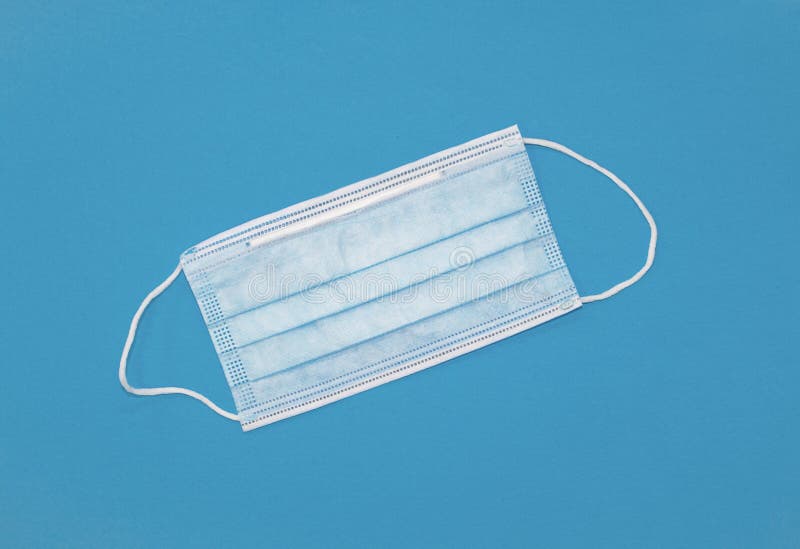Disposable Face Mask Lying on a Blue Background. View from Above Stock ...