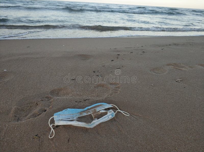 Disposable Face Mask Thrown As Trash on the Beach Stock Photo - Image ...