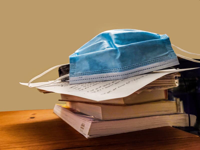 Disposable Face Mask on Top of a Stack of University Books Sitting on a ...