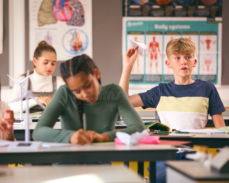 Disruptive Male Secondary or High School Student Throwing Paper Dart in ...