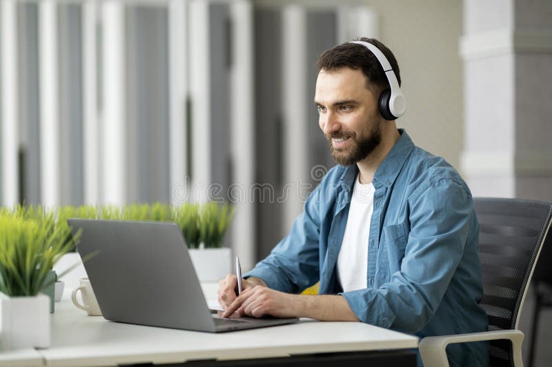 Distance Learning. Man in Headphones Watching Webinar on Laptop and ...