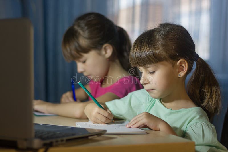 Distance Online Education. Two Schoolgirls Study at Home and Write ...
