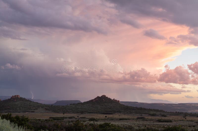 A Distant Bolt of Lightning Drops from Dramatic Pink Tinged Clouds ...