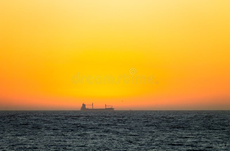 Distant Cargo Ship at Sunset Stock Photo - Image of dusk, blue: 128704638