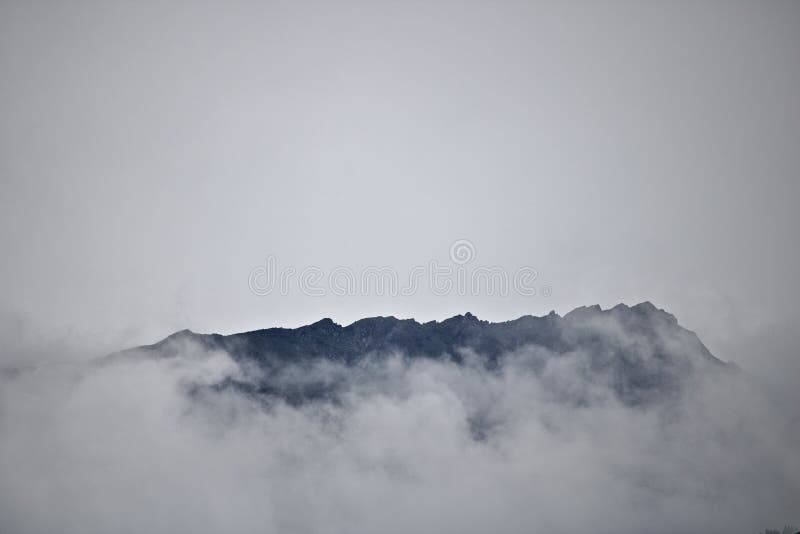 Distant Mountain Ridge Barely Visible Above the Clouds Stock Image ...