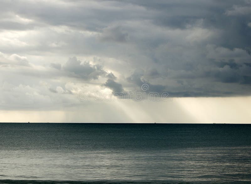 A Distant Rain Over the Sea Stock Photo - Image of cloudy, dramatic ...