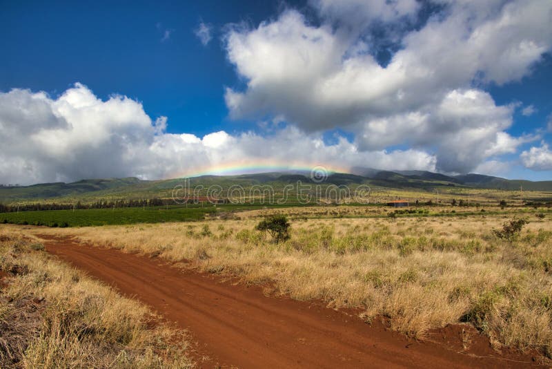 Distant Rainbow Over the Rich Red Dirt of Maui. Stock Image - Image of ...