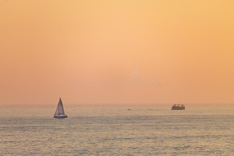 Distant Sailboat at Sunset stock photo. Image of sailing - 122753364